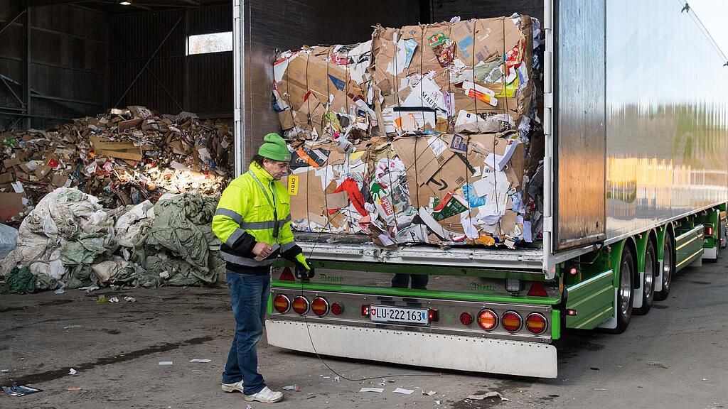 Ein Lastwagenchauffeur holt gepressten Karton ab: Recyclingfirmen ...
