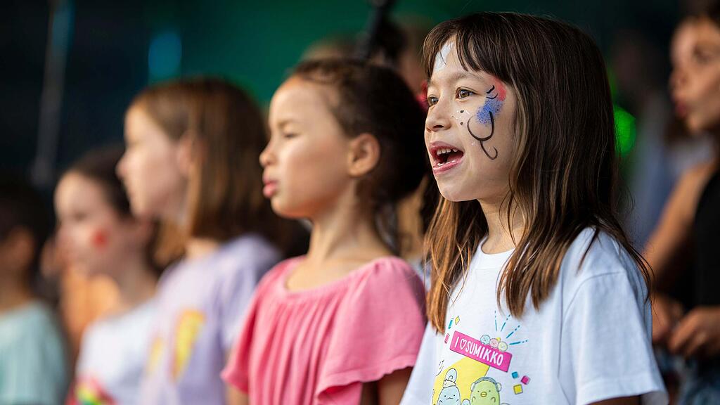 Der Chor Kidsvoice und Teenvoice mit Band während des Auftritts.