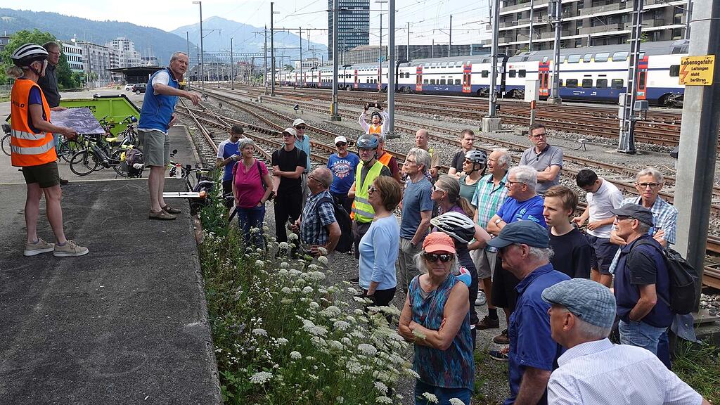 Die Gruppe lauscht am Güterbahnhof in Zug den Ausführungen von Martin ...